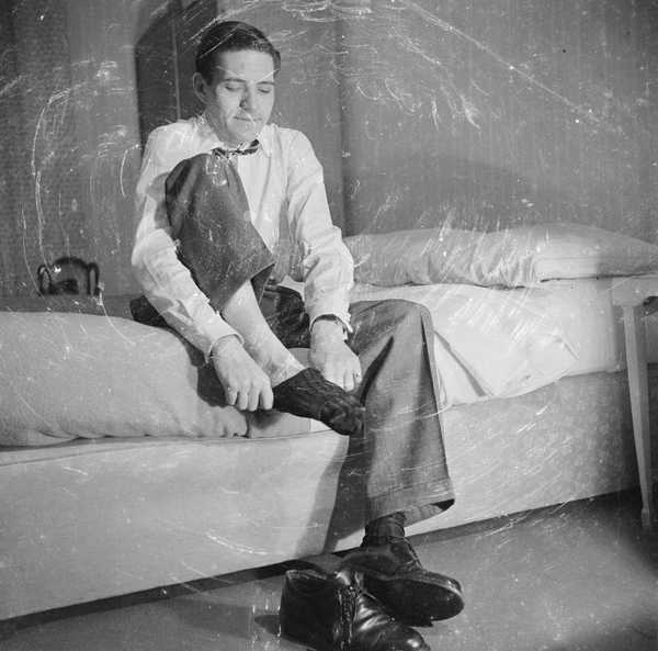 Photograph of Jack Parnell putting on his sock while sitting on the ...