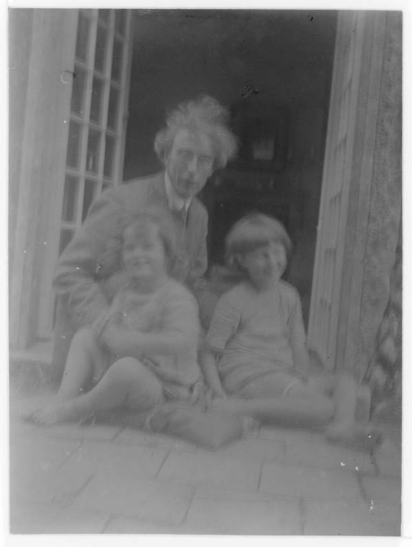 Black and white negative of Roger Fry seated on a step with Julian Bell ...