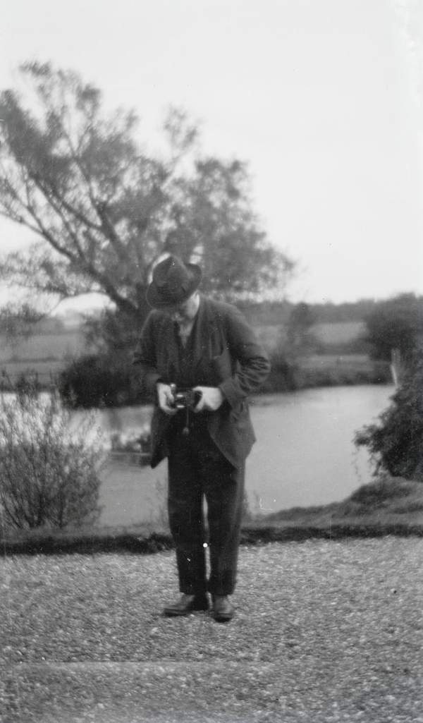 Black and white negative of George Herbert Duckworth holding a camera ...