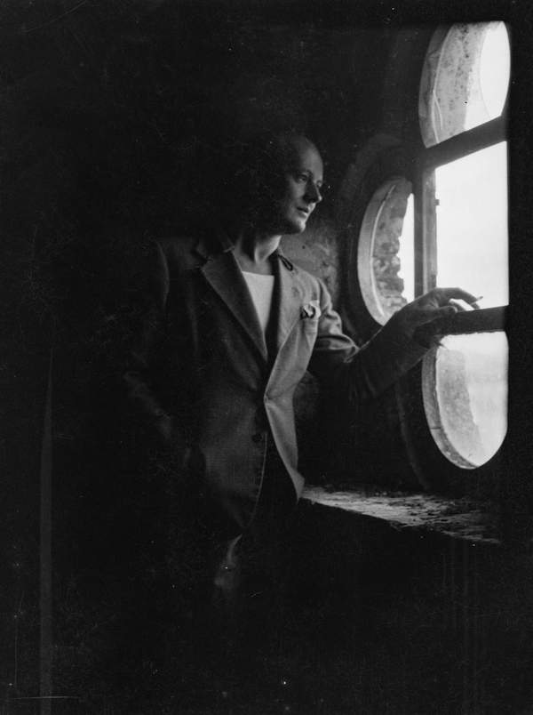 Black and white negative of Angus Davidson looking through a window at ...