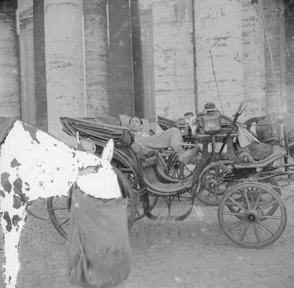 Photograph of an unidentified man lying in a horse-drawn carriage ...