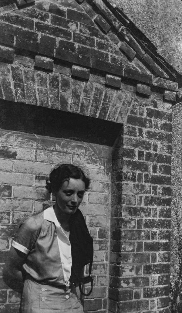 Black and white negative of Elizabeth Watson posing in front of a brick ...