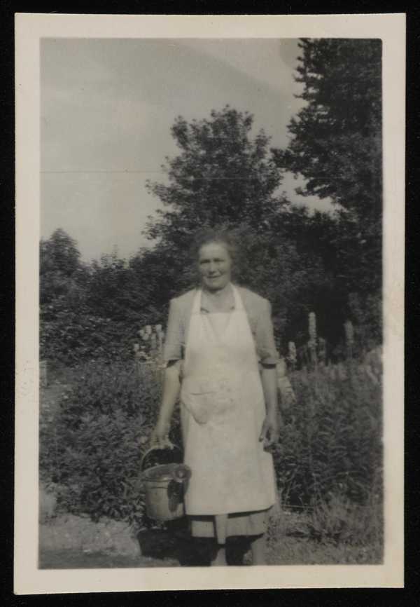 Photograph of Marie Hauptmann holding a watering can in the garden at ...