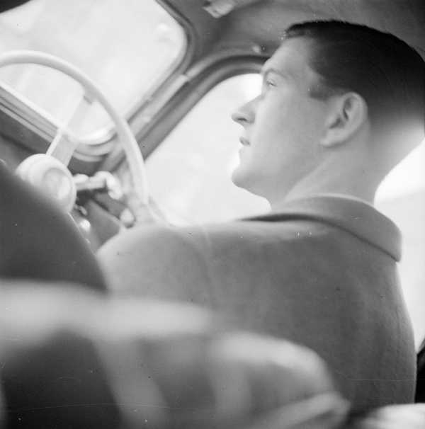 Photograph of an unidentified man driving a car, possibly Jack Parnell ...