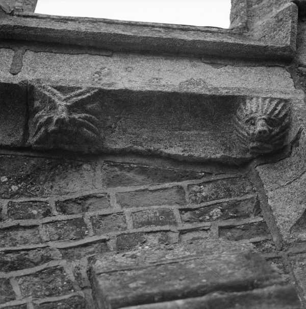 Photograph of detail of a parapet and corbel heads on a church in ...