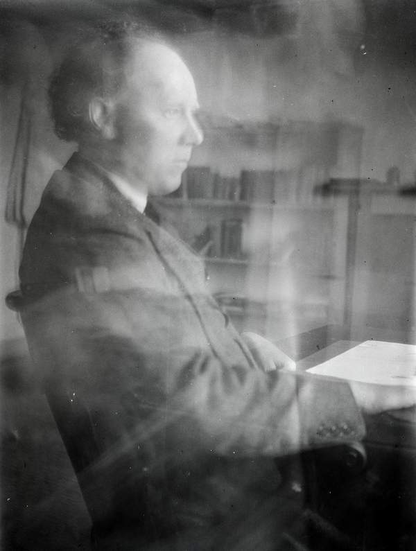 Black and white negative of Clive Bell in profile, seated indoors at ...