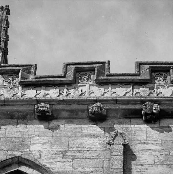 Photograph of detail of a parapet and corbel heads on a church in ...