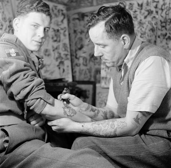 Photograph showing an unidentified man getting a tattoo on his right ...