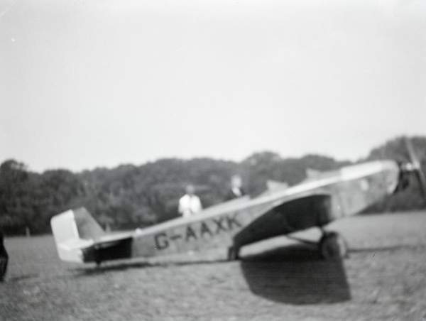 Black and white negative of David Garnett standing behind an aeroplane ...