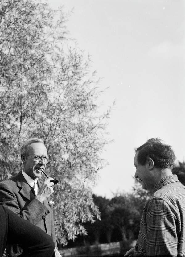 Black and white negative of Adrian Stephen smoking a pipe and looking at Duncan Grant, outdoors ...