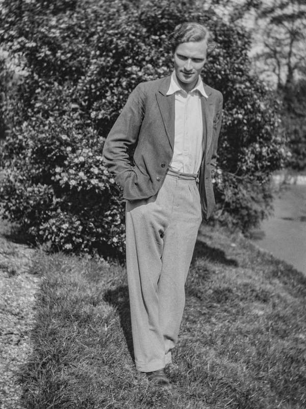 Black and white negative of John Lehmann standing in the garden at ...