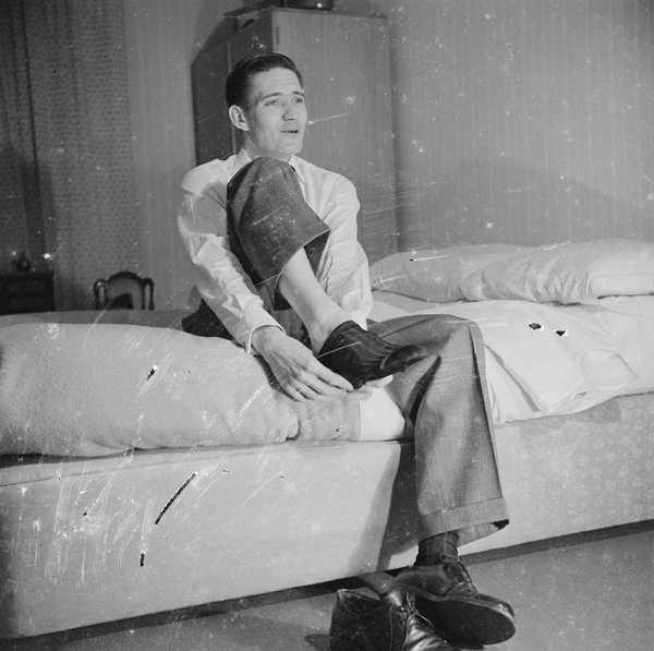 Photograph of Jack Parnell putting on his sock while sitting on the ...