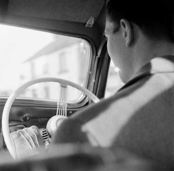 Photograph showing an unidentified man driving a car, possibly Jack ...