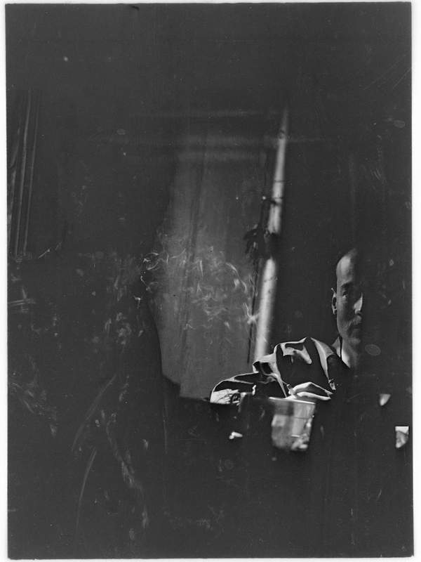 Black and white negative of Angus Davidson seated indoors [in Cassis ...