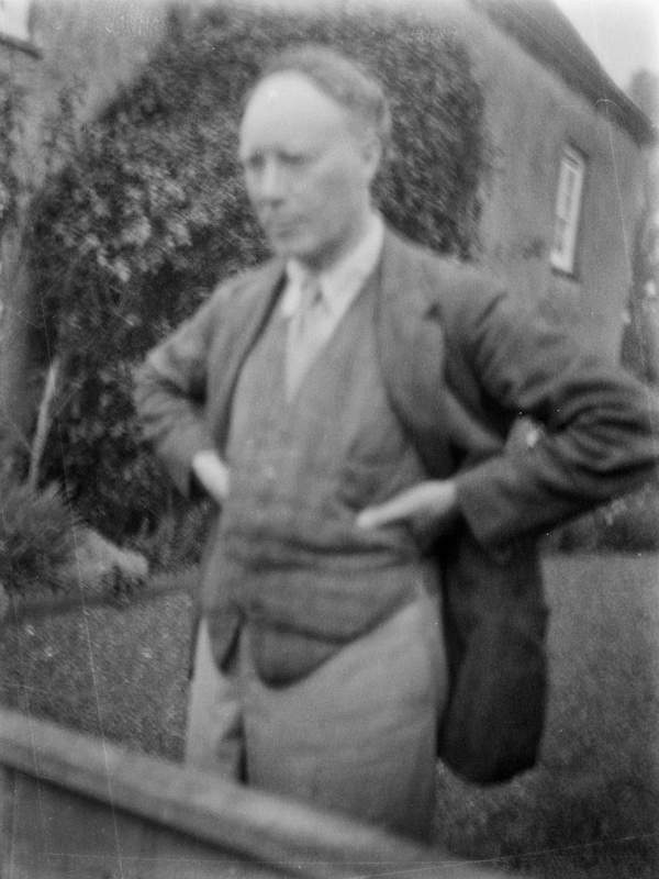 Black and white negative of Clive Bell with his hands on his hips in ...