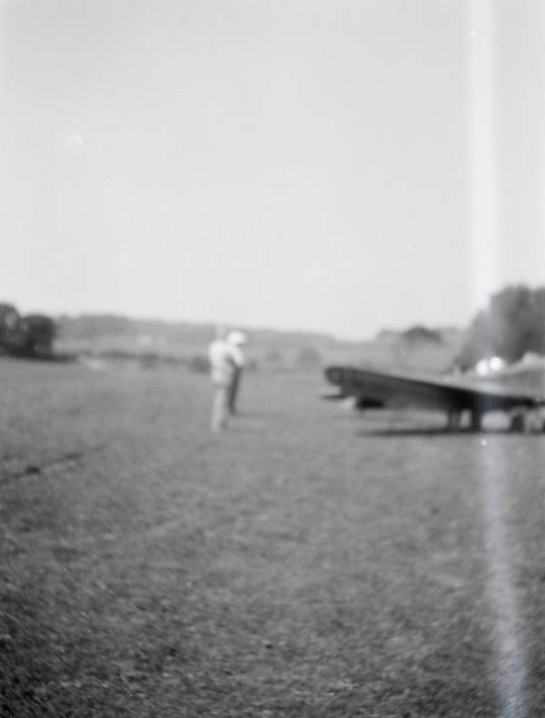 Black and white negative of David Garnett next to an aeroplane at ...