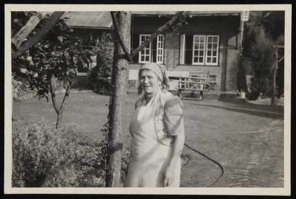 Photograph of Marie Hauptmann standing next to an arbour in the garden ...